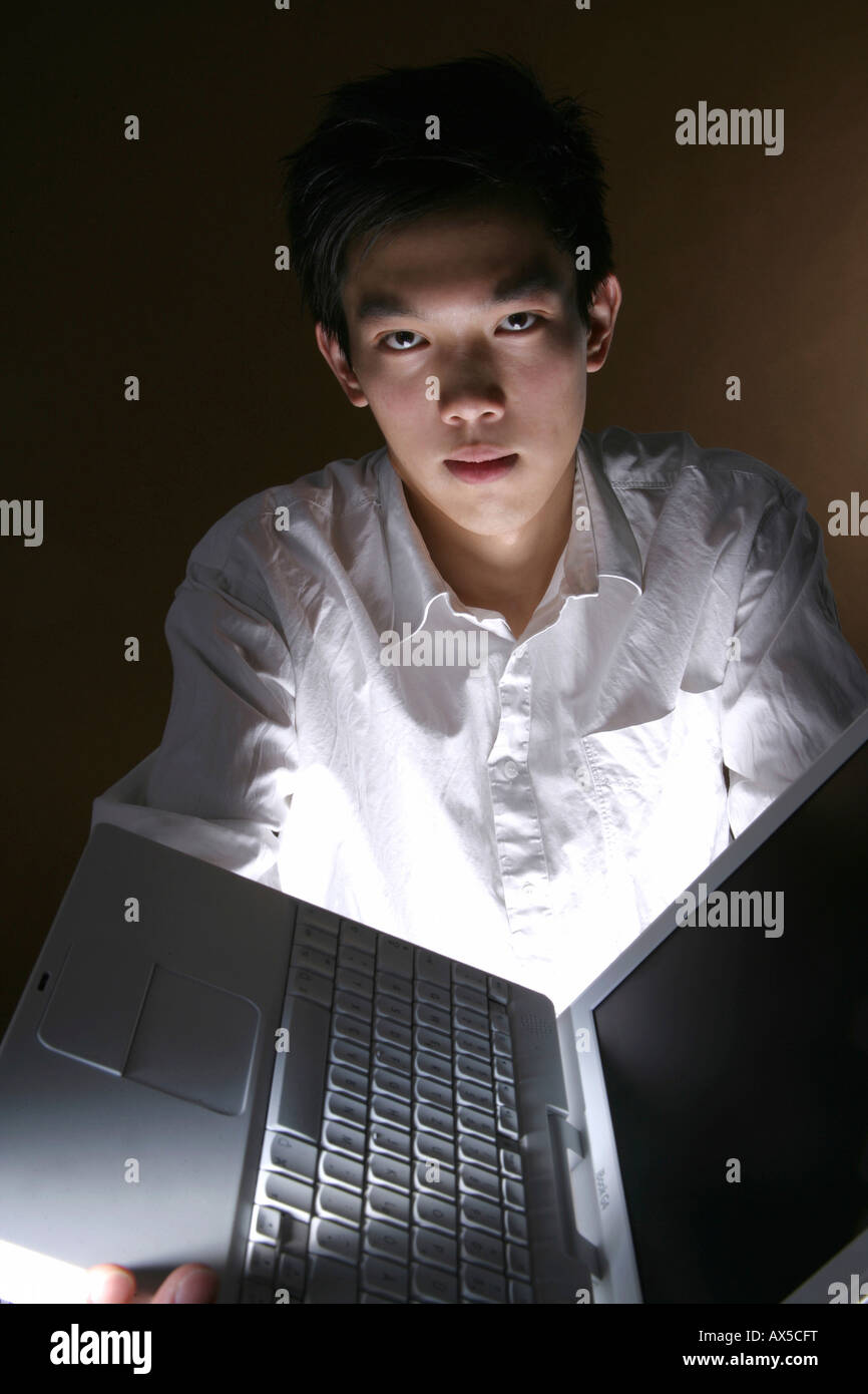 Young man holding laptop with outstretched arms Stock Photo - Alamy