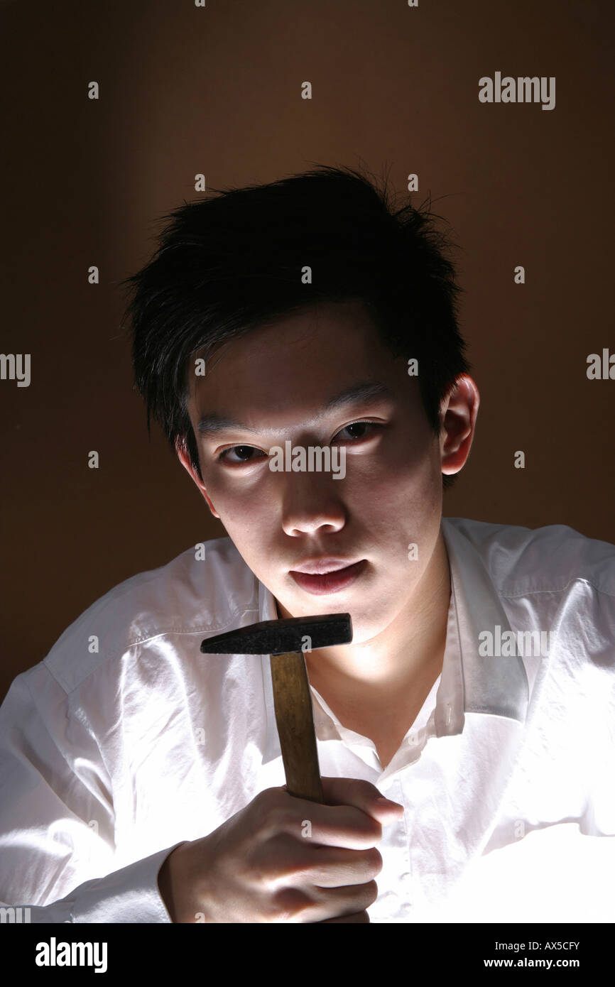 Young man holding a hammer Stock Photo - Alamy