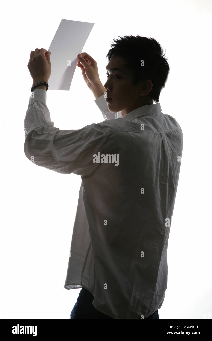 Man holding sheet of paper in his hands Stock Photo - Alamy
