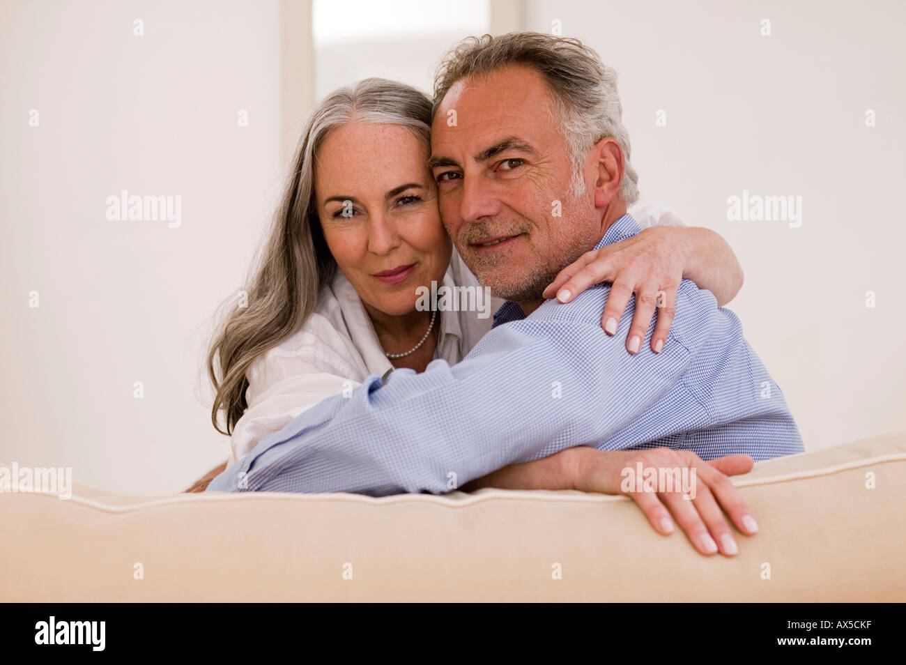 Mature couple embracing on sofa, close-up, portrait Stock Photo - Alamy