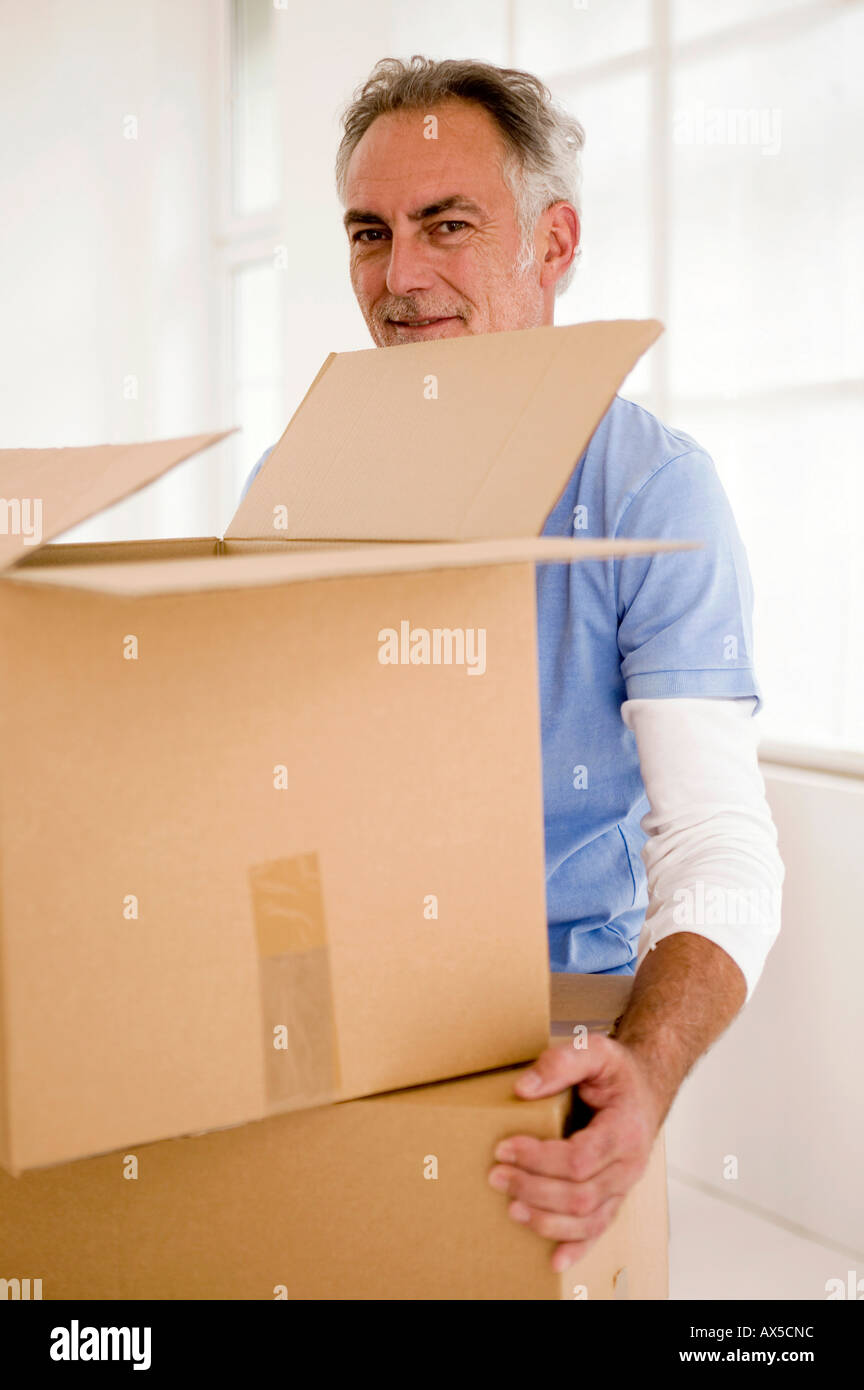 Mature man holding carton, portrait, smiling Stock Photo - Alamy