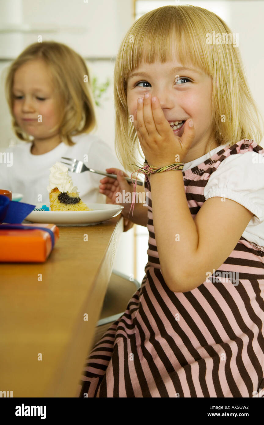 Two girls (4-5) eating cake in kitchen Stock Photo - Alamy