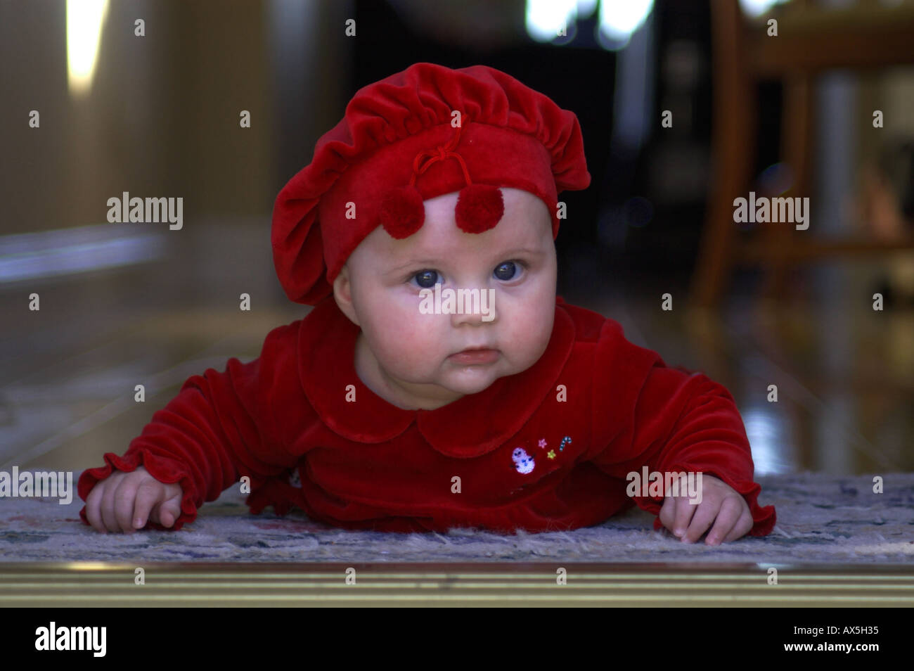 baby in red outfit on stomach Stock Photo - Alamy