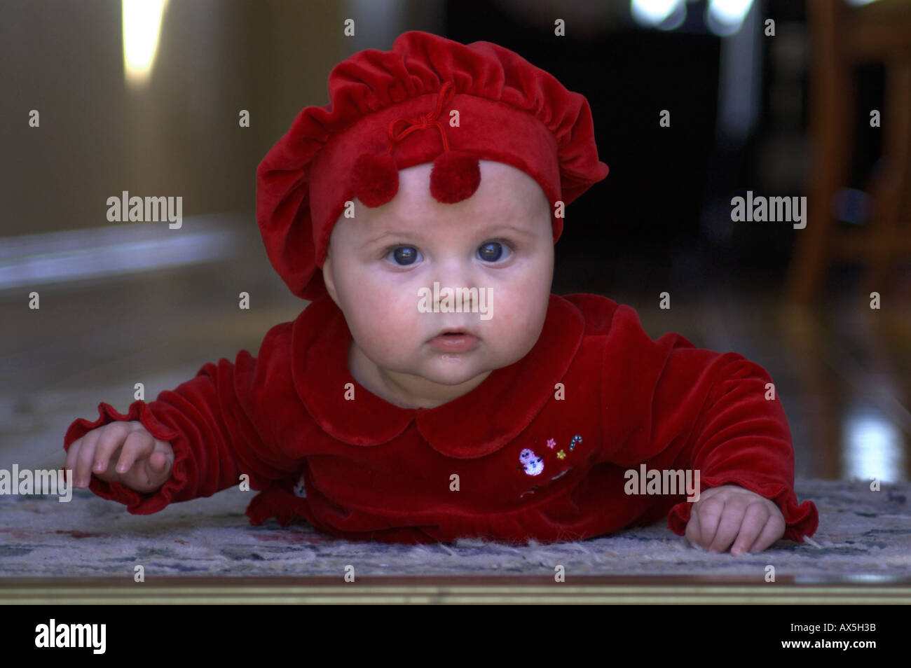 baby in red outfit on stomach Stock Photo - Alamy