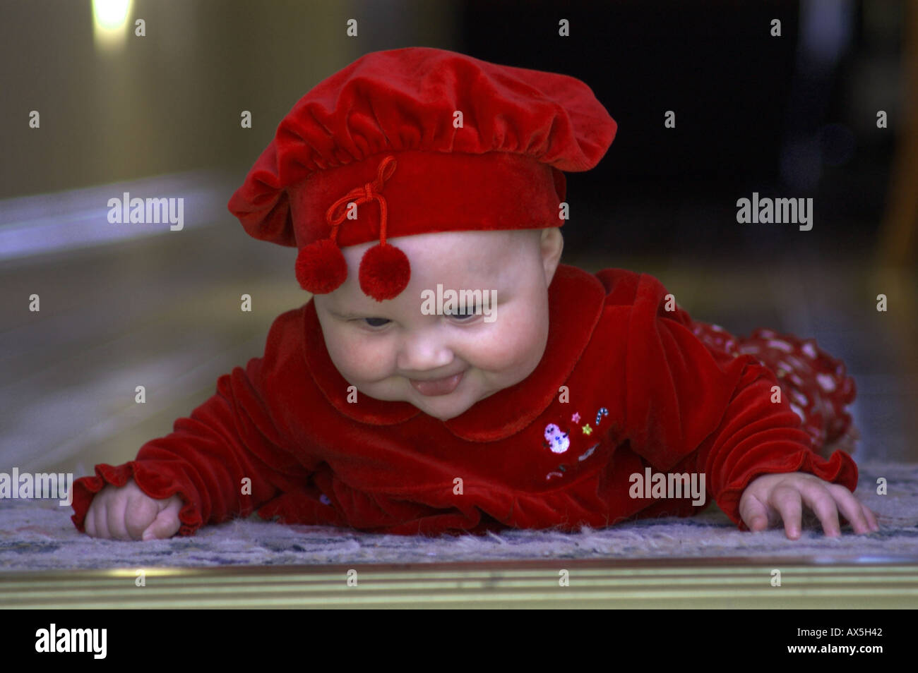 baby in red outfit on stomach Stock Photo - Alamy