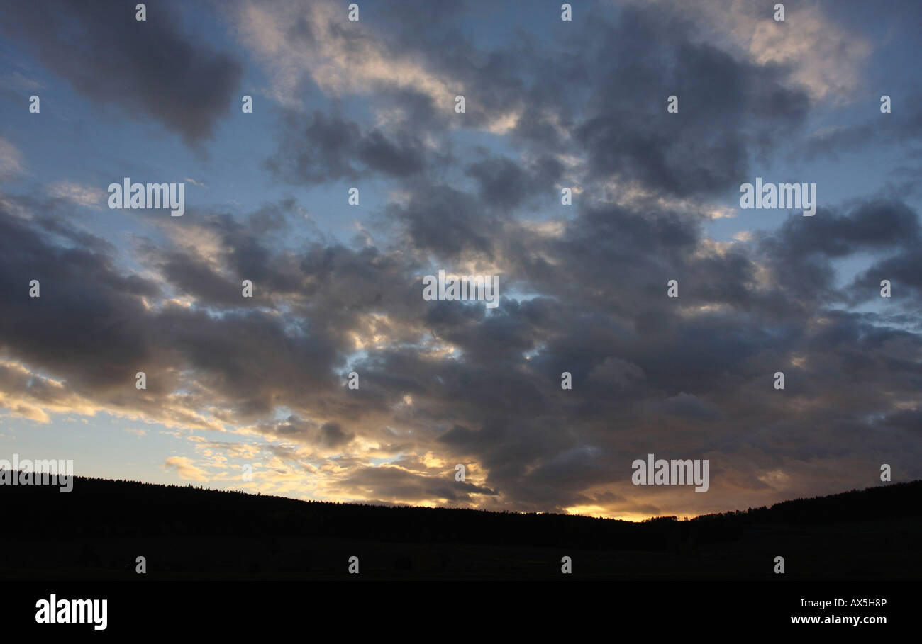 Thunderclouds above a dark landscape, sunrays in front of sunset Stock ...