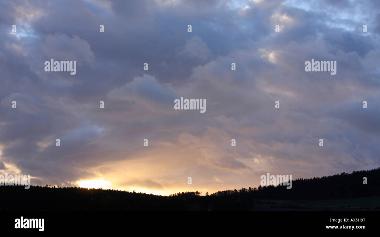 Thunderclouds above a dark landscape, sunrays in front of sunset Stock ...