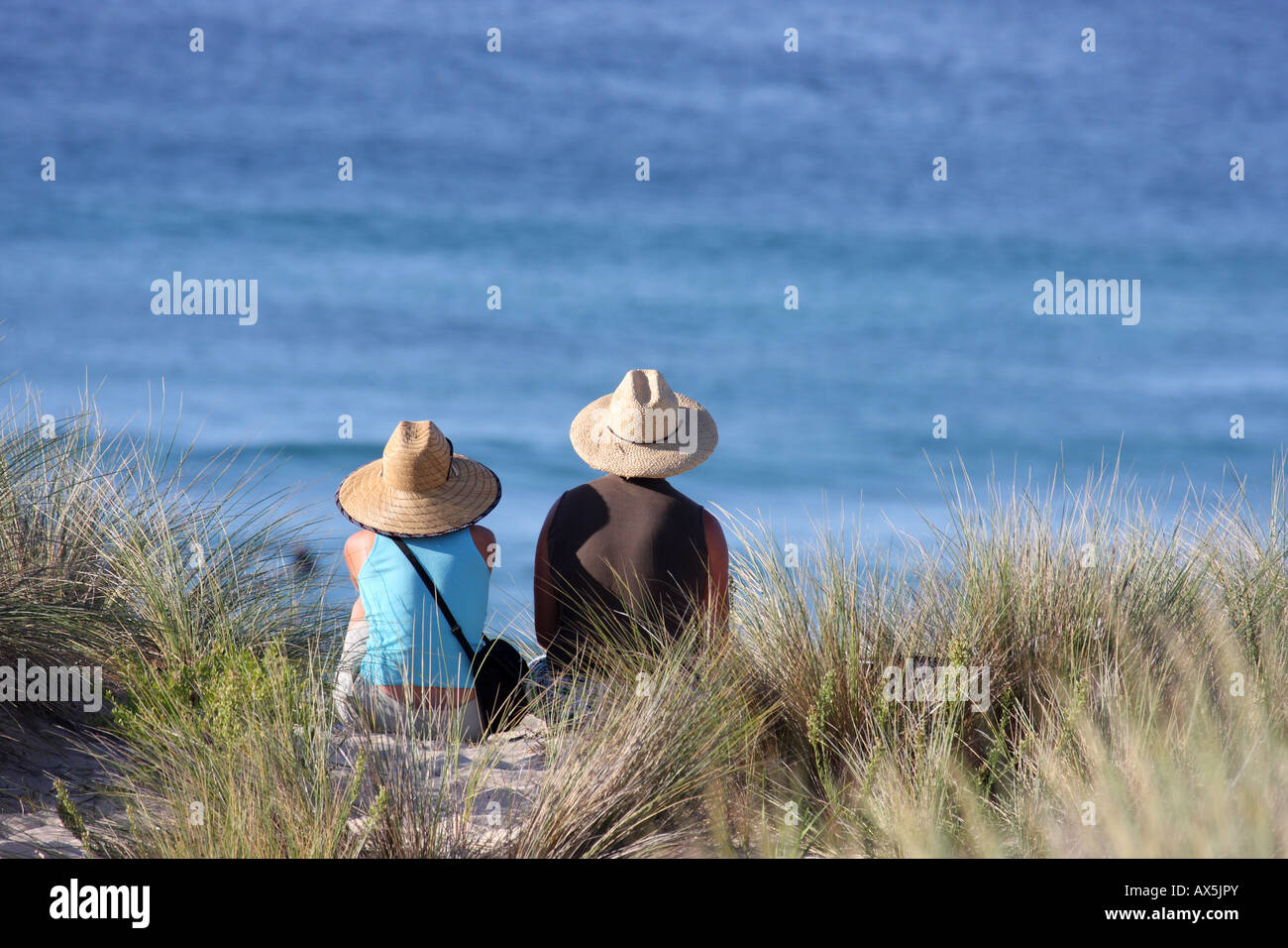 Two people look out over a blue sea on a sunny day Stock Photo - Alamy
