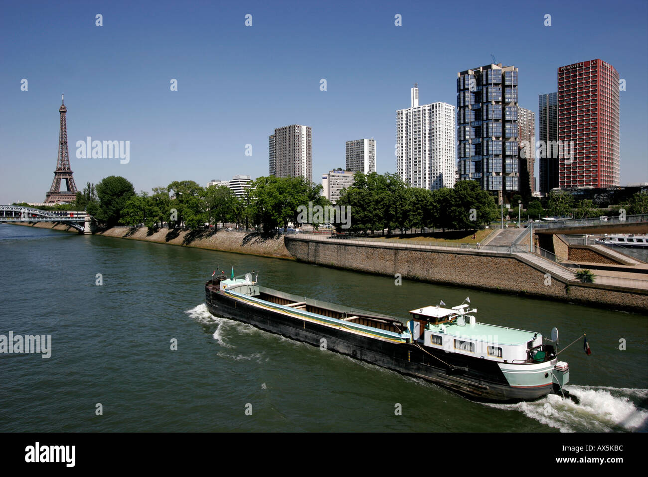 View of River Seine with a barge and Eiffel Tower and high-rise ...
