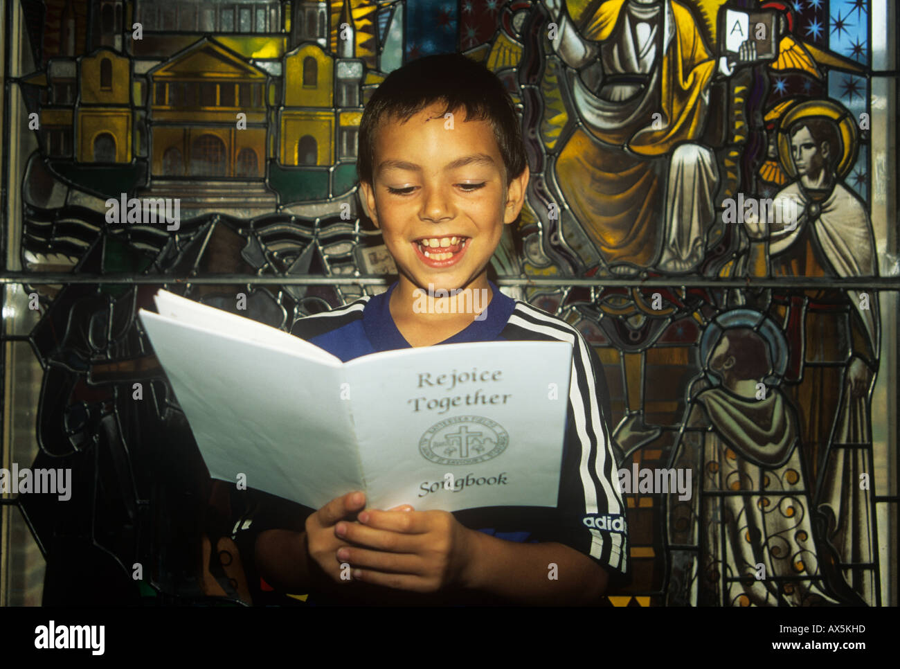 Young Christian boy singing a hymn during Sunday service in an Anglican ...
