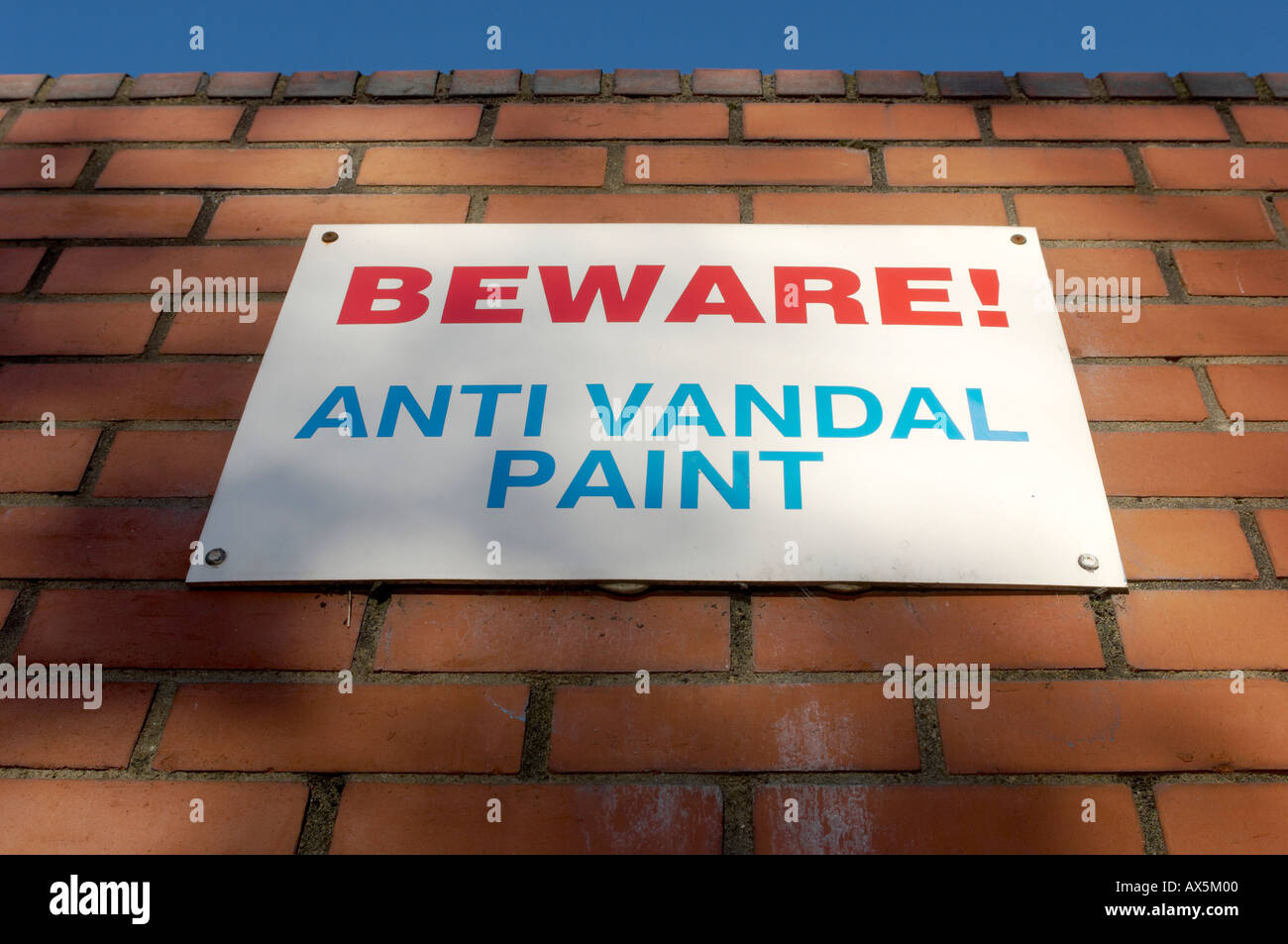 Beware Anti Vandal Paint sign mounted on a brick wall seen against a ...