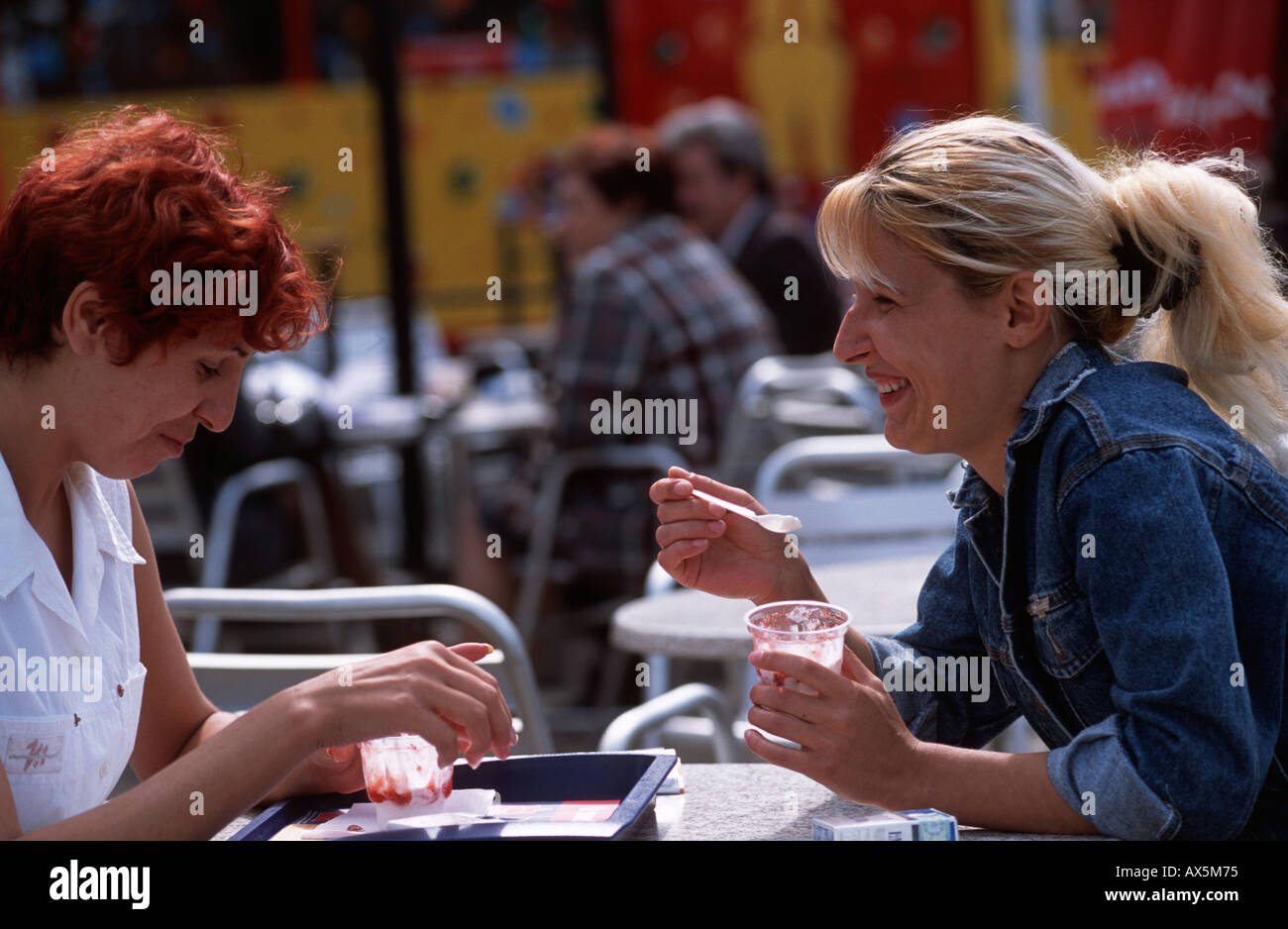 Bucharest, Romania. Two women eating icecream; packet of cigarettes on ...