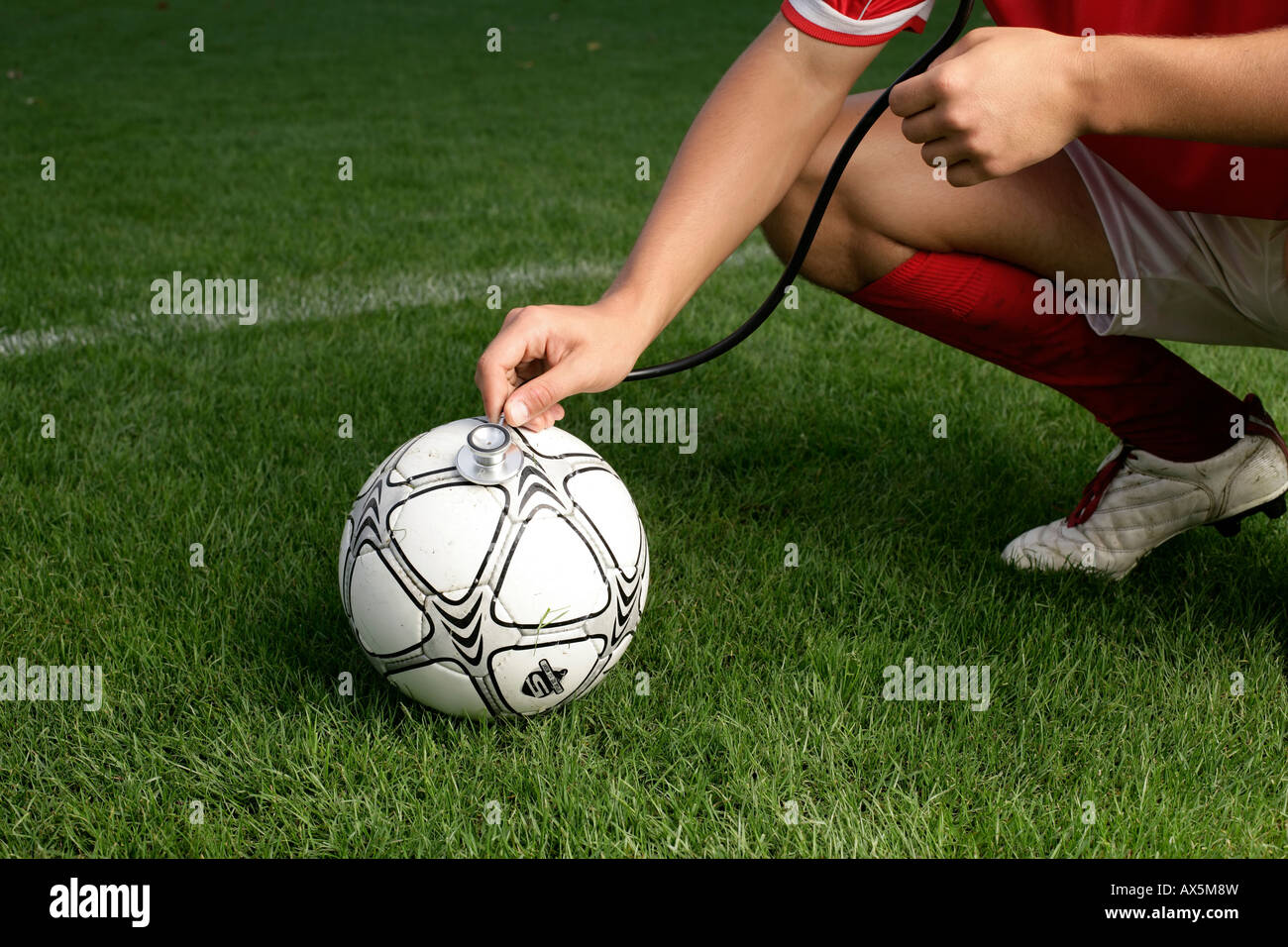 Soccer player checking football with a stethoscope Stock Photo - Alamy