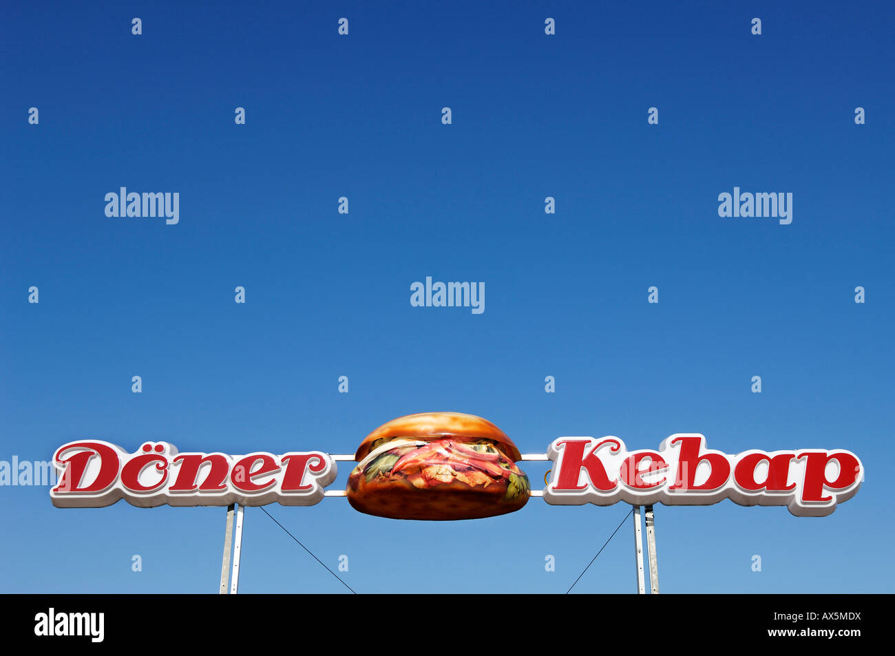 Advertising for a doener kebab (donair) shop against a blue sky in ...