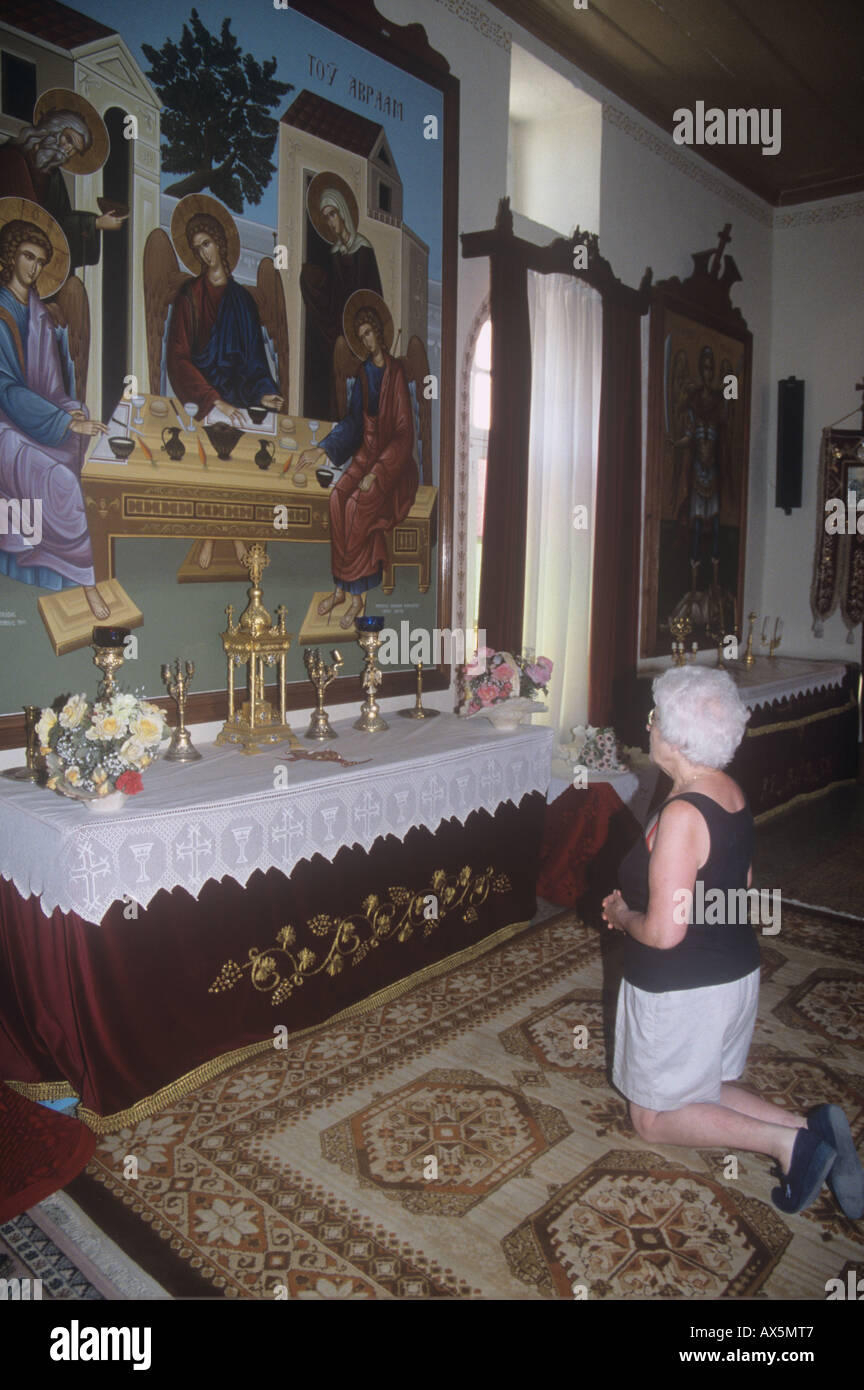 An English tourist kneels in front of an altar in Panormitis Greek ...