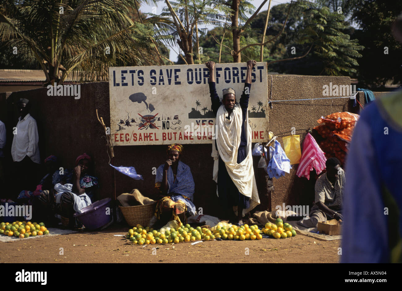 Banjul, The Gambia. People selling fruit on the street below a sign ...