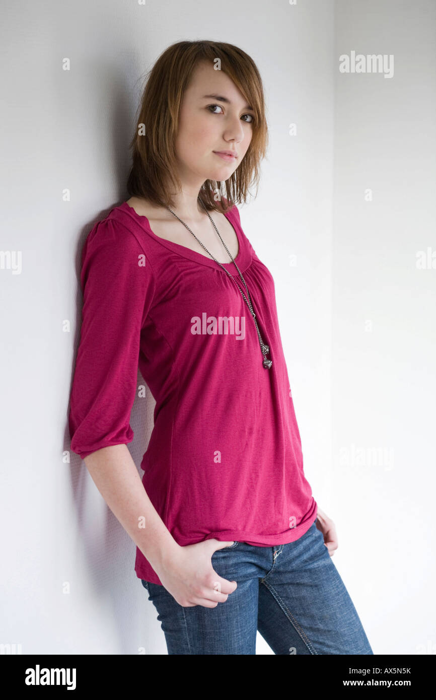 Young woman leaning against the wall Stock Photo - Alamy