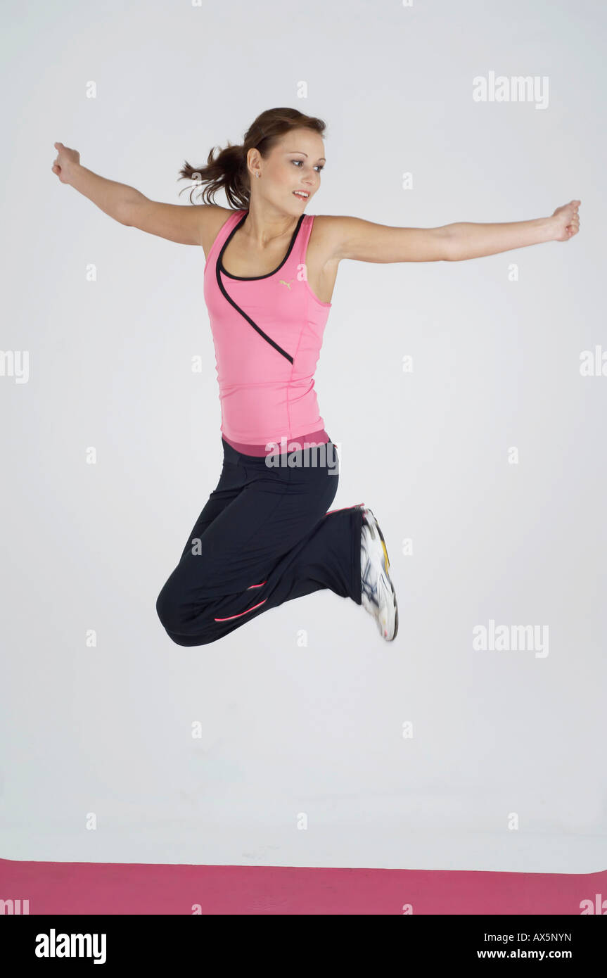 Young woman jumping into the air during a workout Stock Photo - Alamy