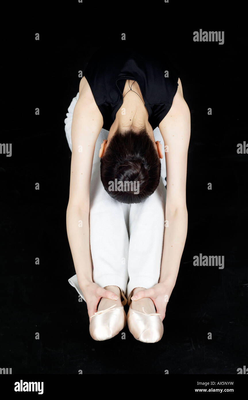 Ballet dancer sitting on the floor lengthwise, stretching Stock Photo ...