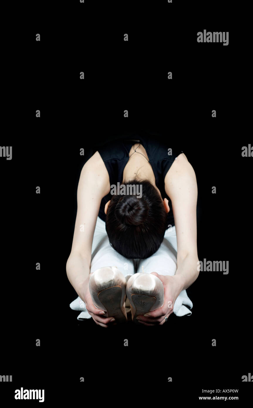 Ballet dancer sitting on the floor lengthwise, stretching Stock Photo ...