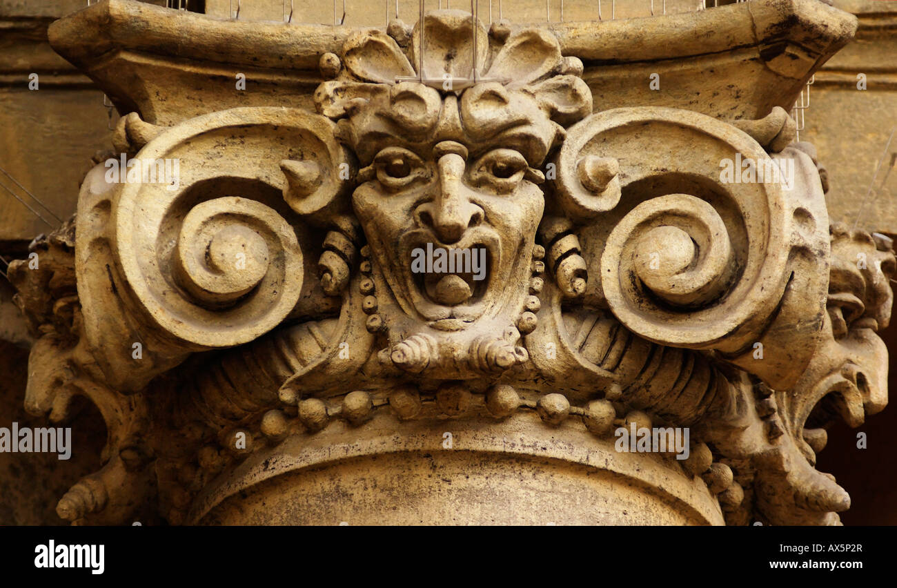 Stone face atop a pillar on a building facade in the historic centre of ...
