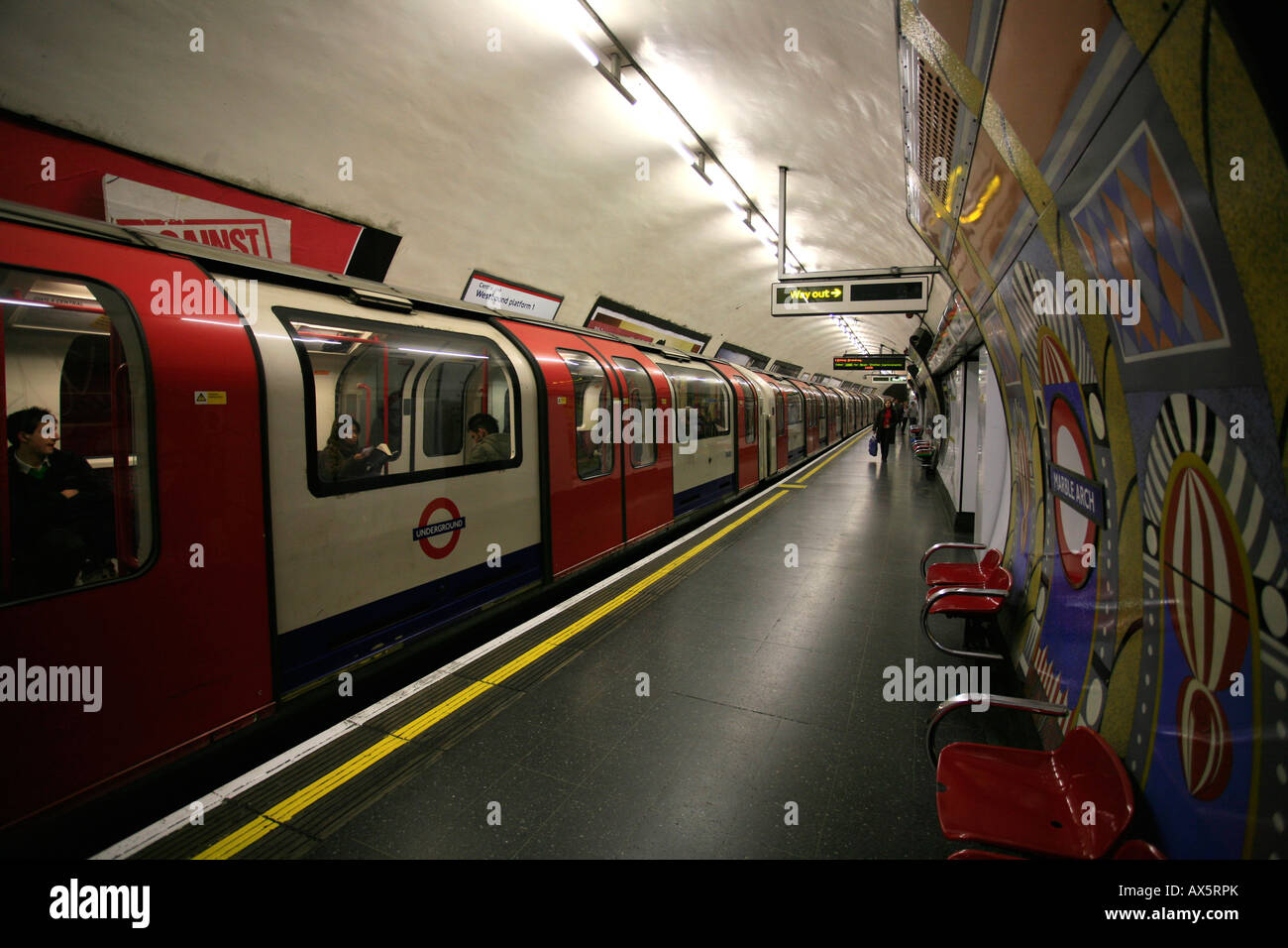 Tube logo, colorful tiles and train arriving at London Arch underground ...