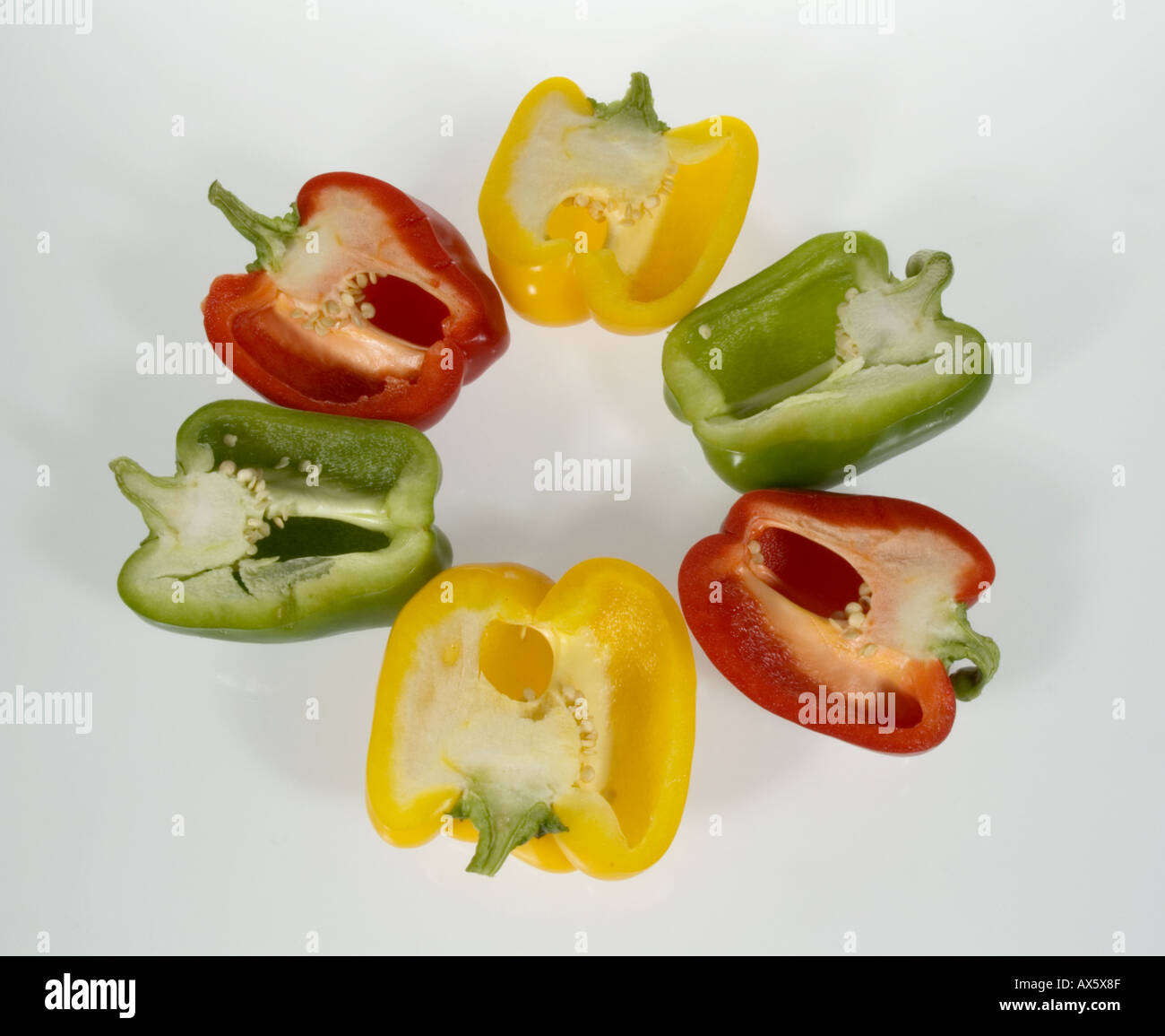 A selection of raw/uncooked peppers cut in half arranged in a circle ...