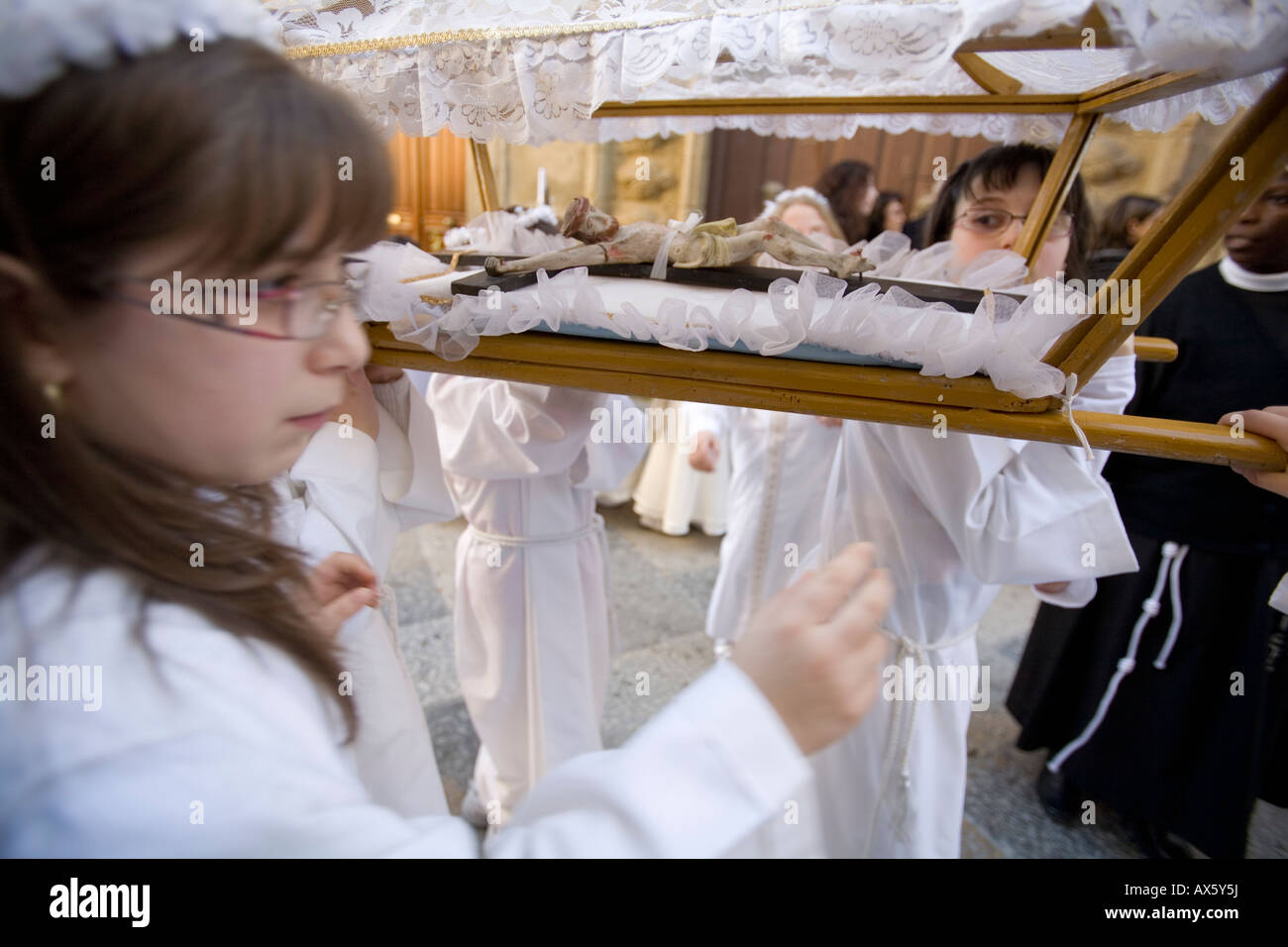 Girls carrying a little statue of Christ during the Holy Week in Assoro ...