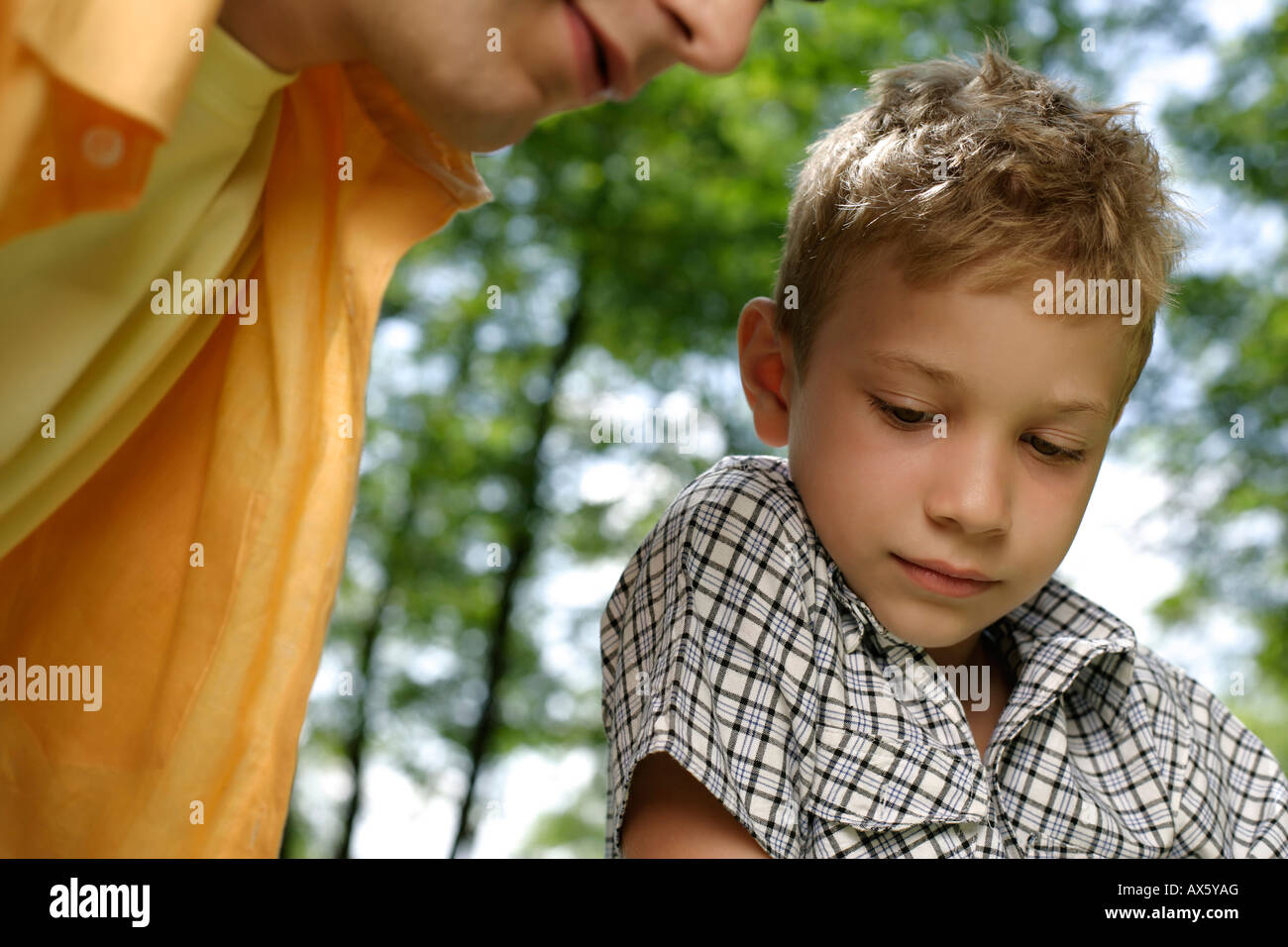 Father and son sitting side by side Stock Photo - Alamy