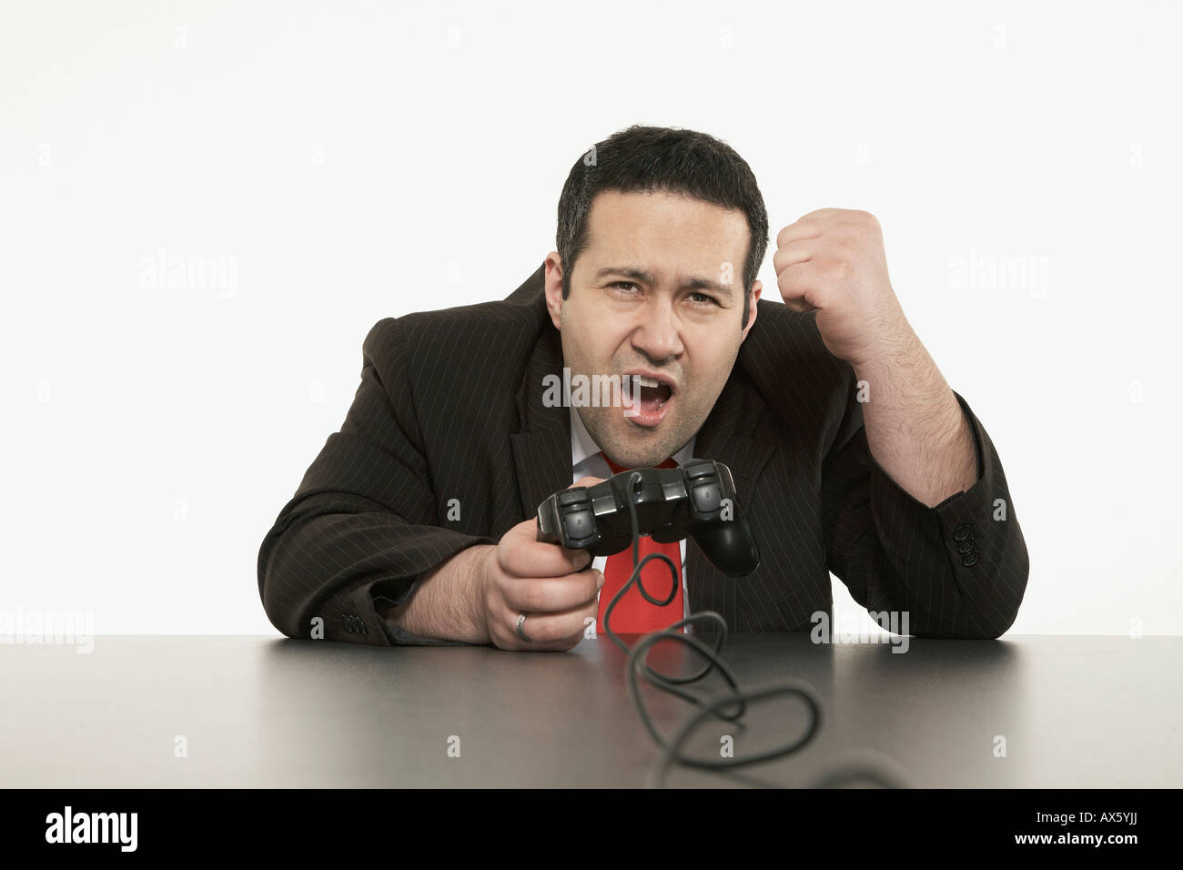 Businessman playing video games at his desk Stock Photo - Alamy