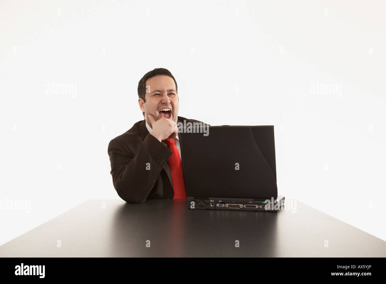 Business man sitting in front of his laptop, laughing Stock Photo - Alamy