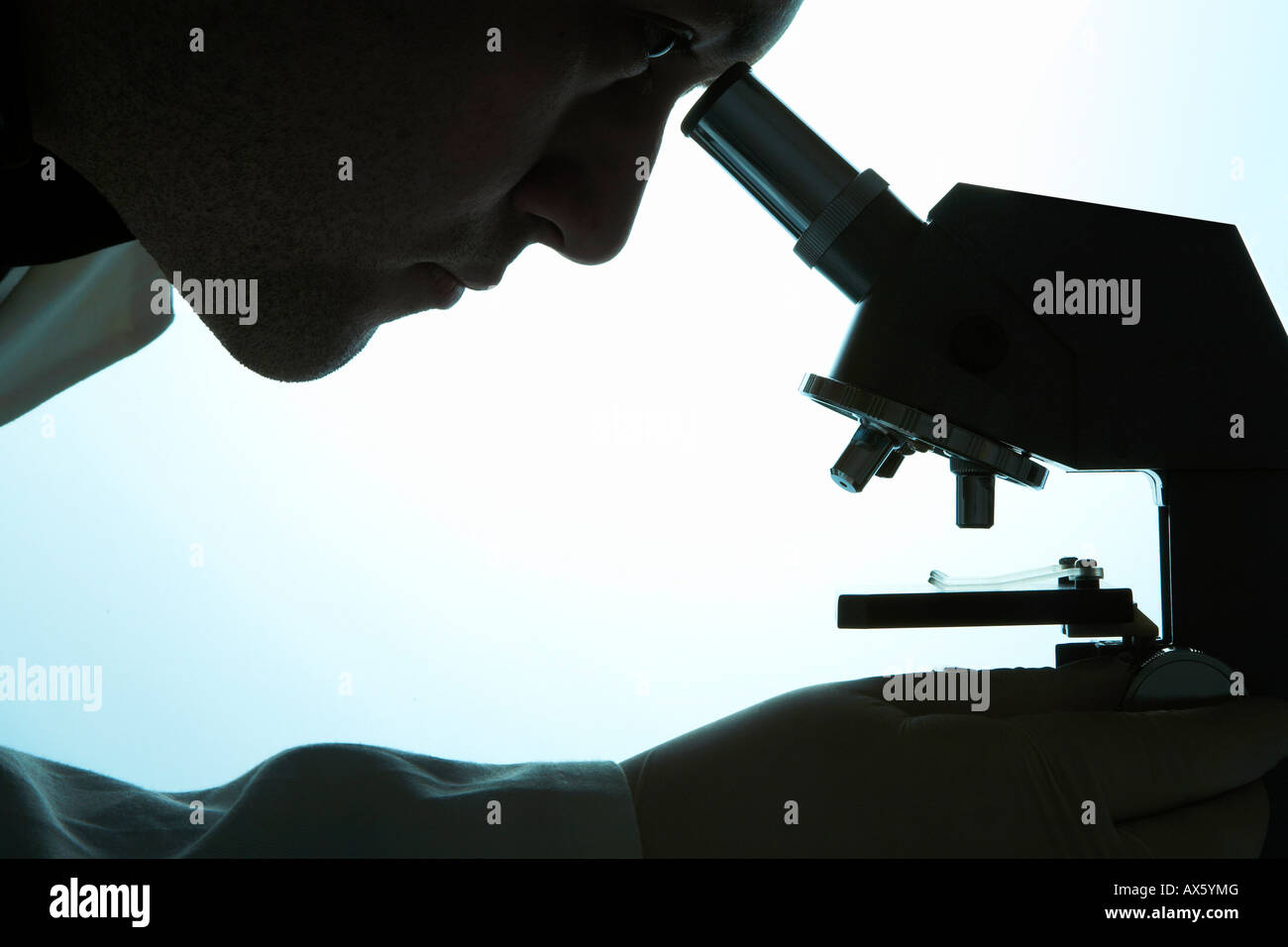 Chemist looking through a microscope Stock Photo - Alamy