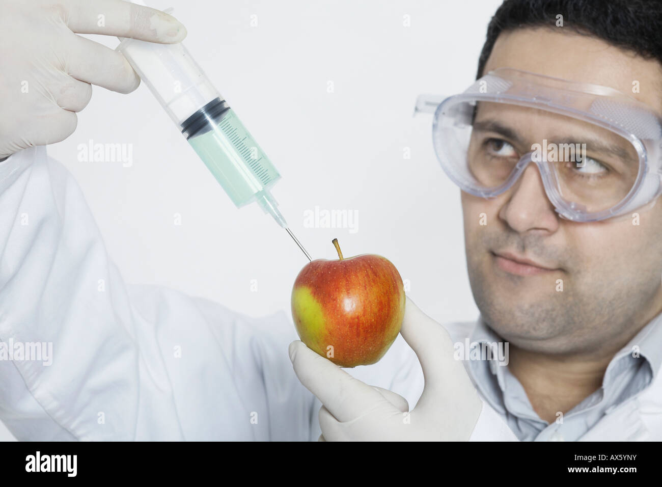 Chemist injecting substance into an apple Stock Photo - Alamy