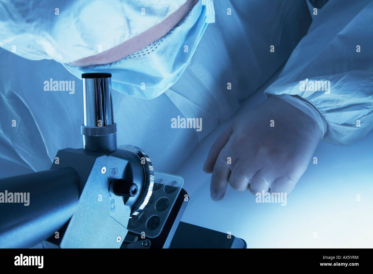 Chemist looking through a microscope Stock Photo - Alamy