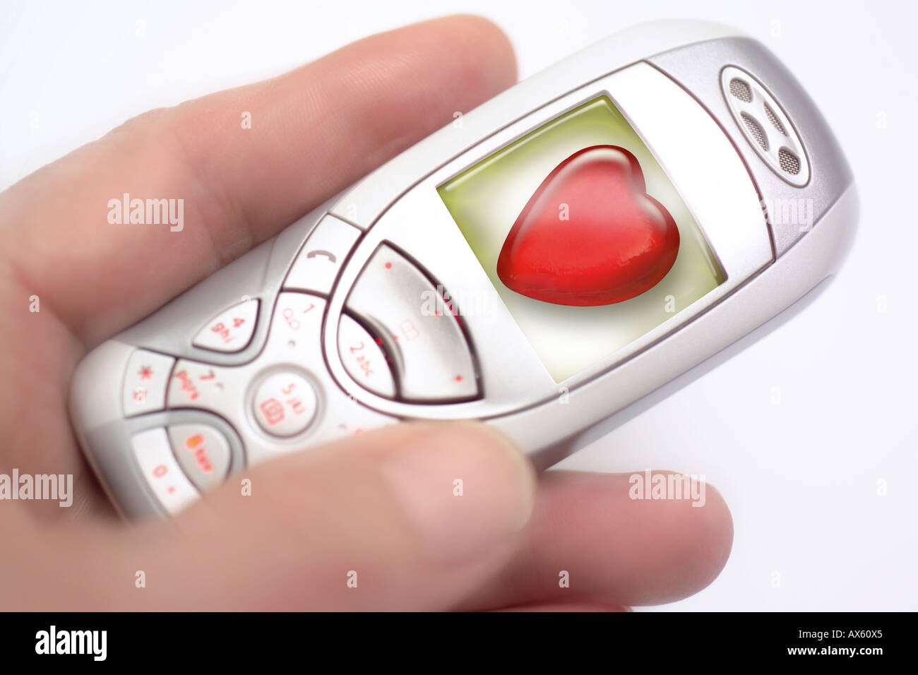 Mobile phone displaying heart shape symbol, close-up Stock Photo - Alamy