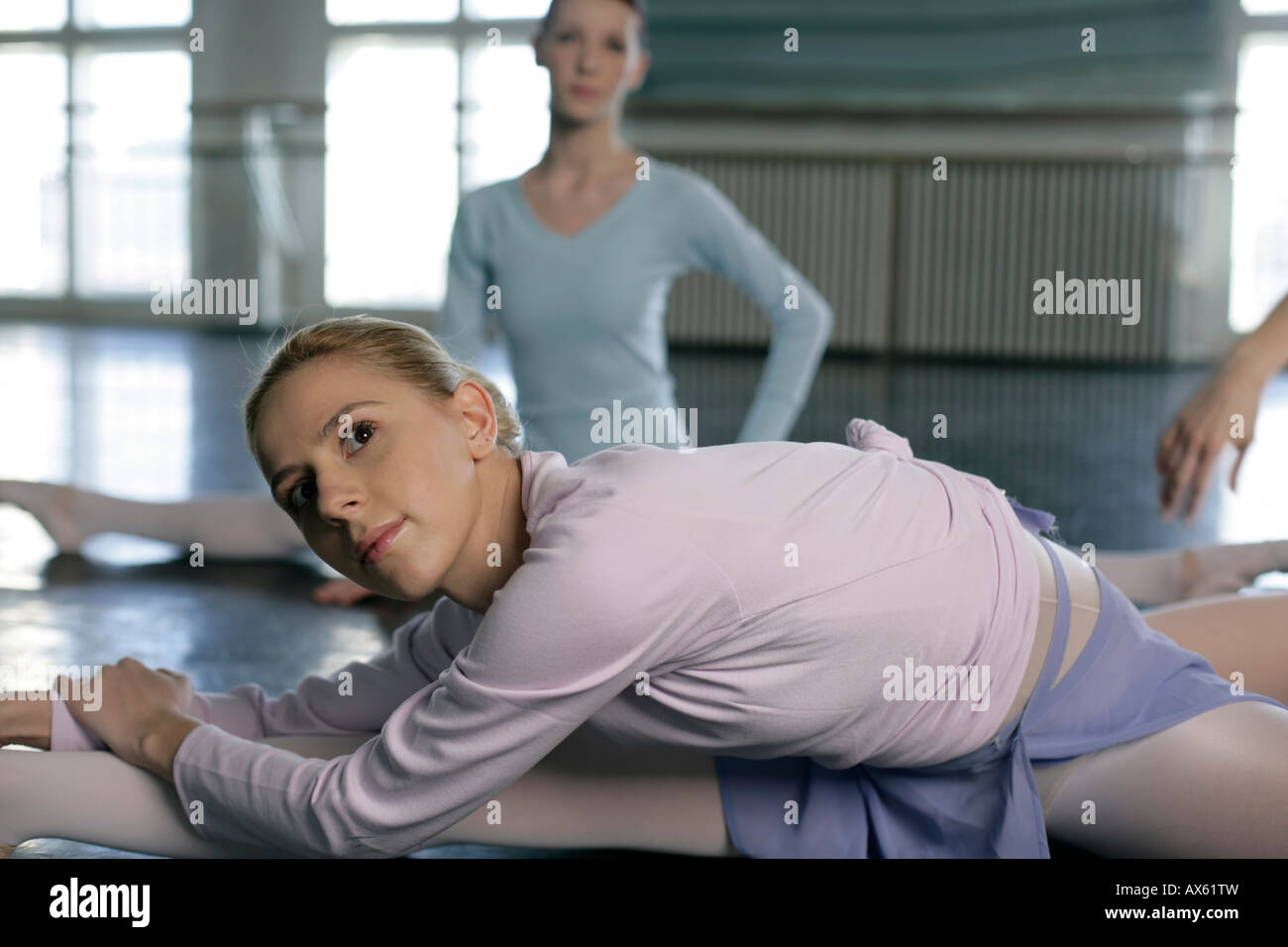 Female ballet dancers doing stretching exercises on the floor Stock ...