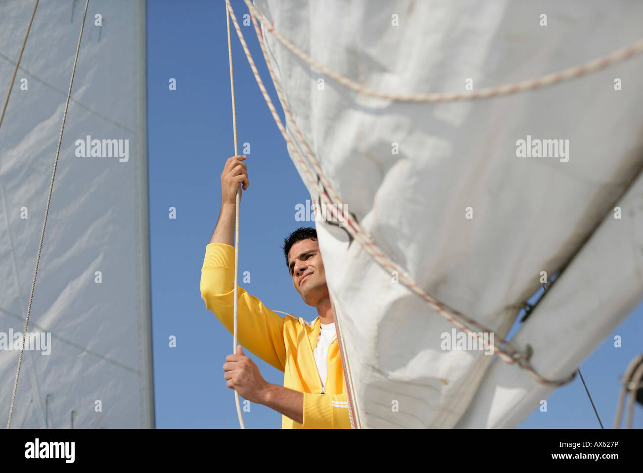 Man hoisting a sail Stock Photo - Alamy