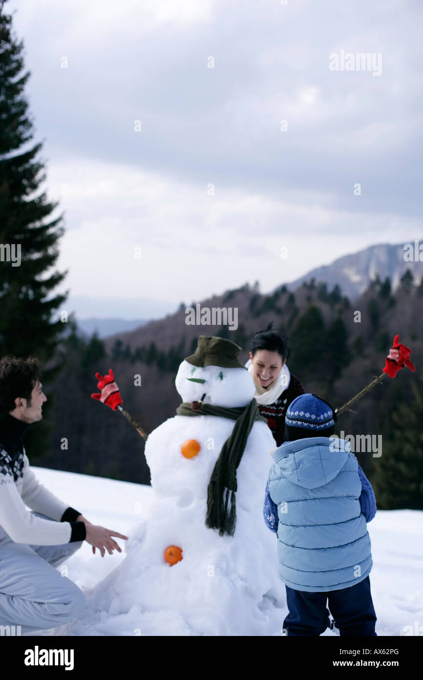 Family making a snowman Stock Photo - Alamy