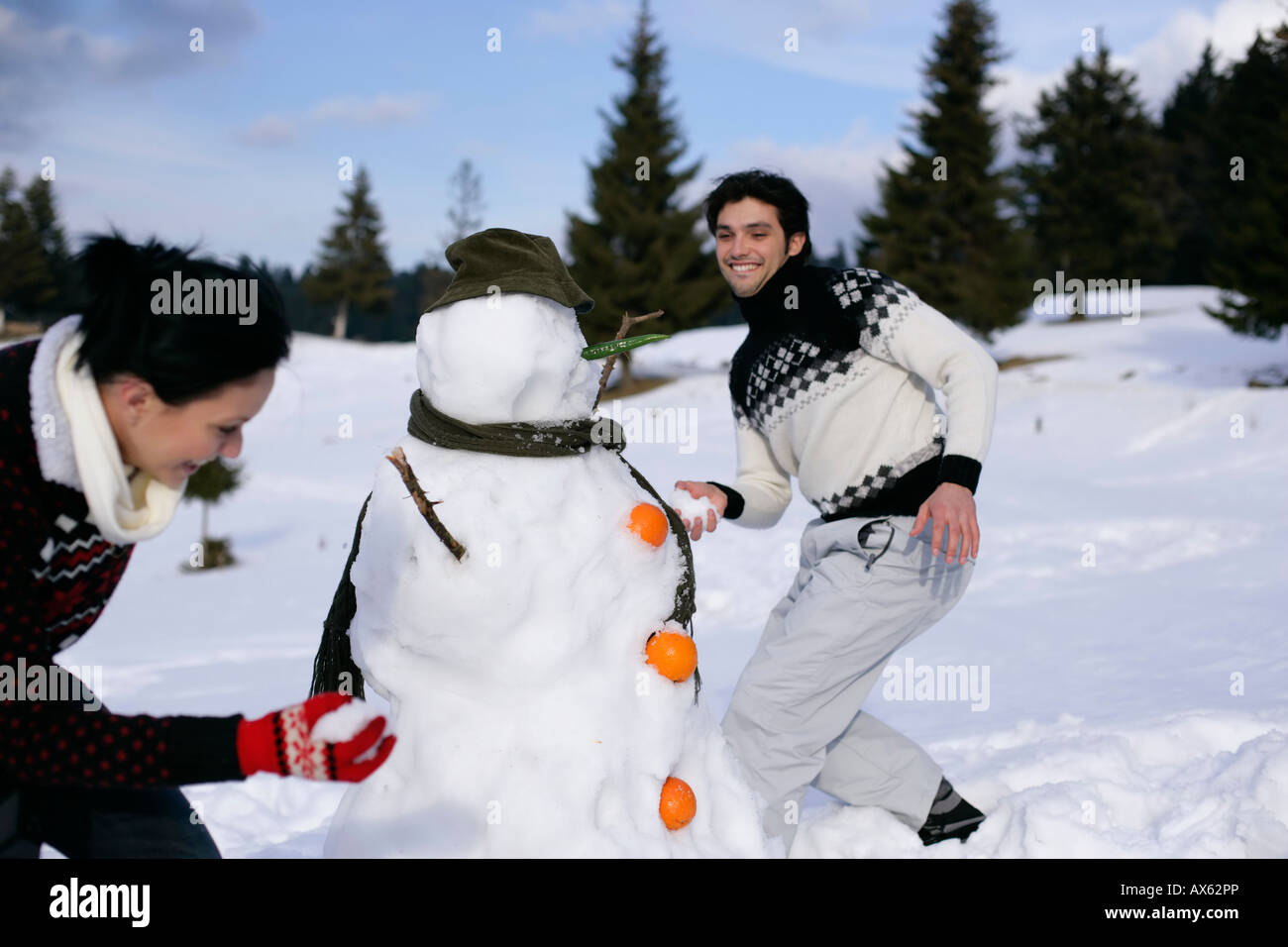 Young couple having snowball fight Stock Photo - Alamy