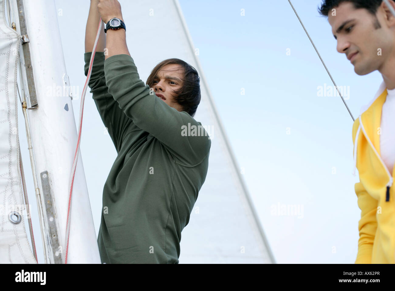 Two men hoisting a sail Stock Photo - Alamy