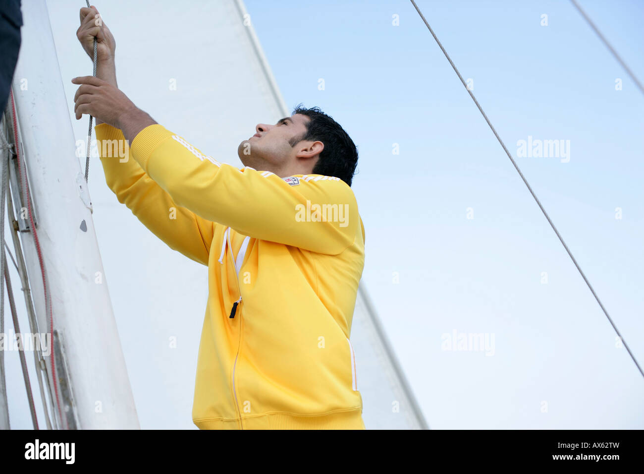 Man hoisting a sail Stock Photo - Alamy