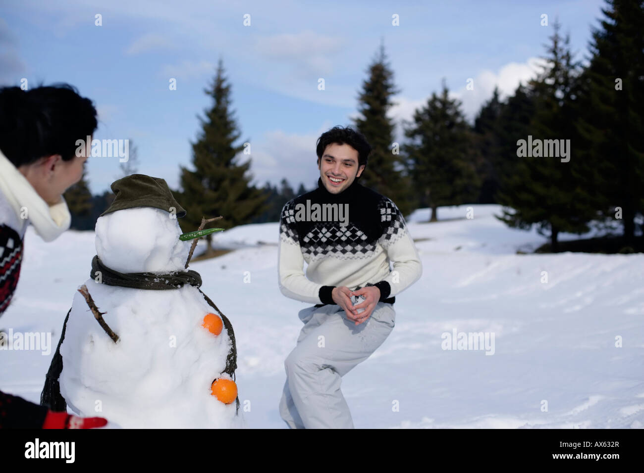Young couple having snowball fight Stock Photo - Alamy