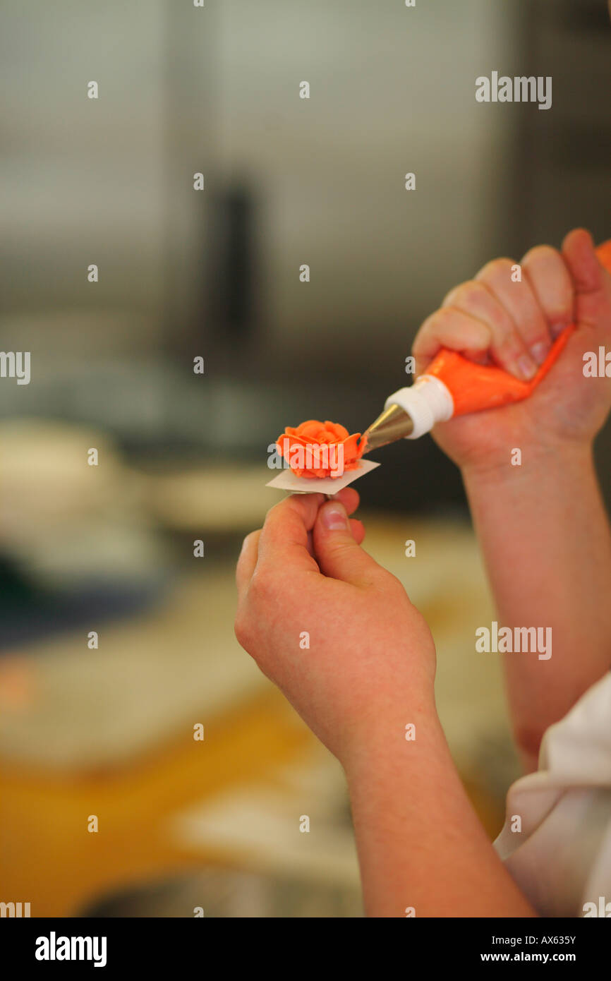 Pastry chef making red icing rose Stock Photo - Alamy