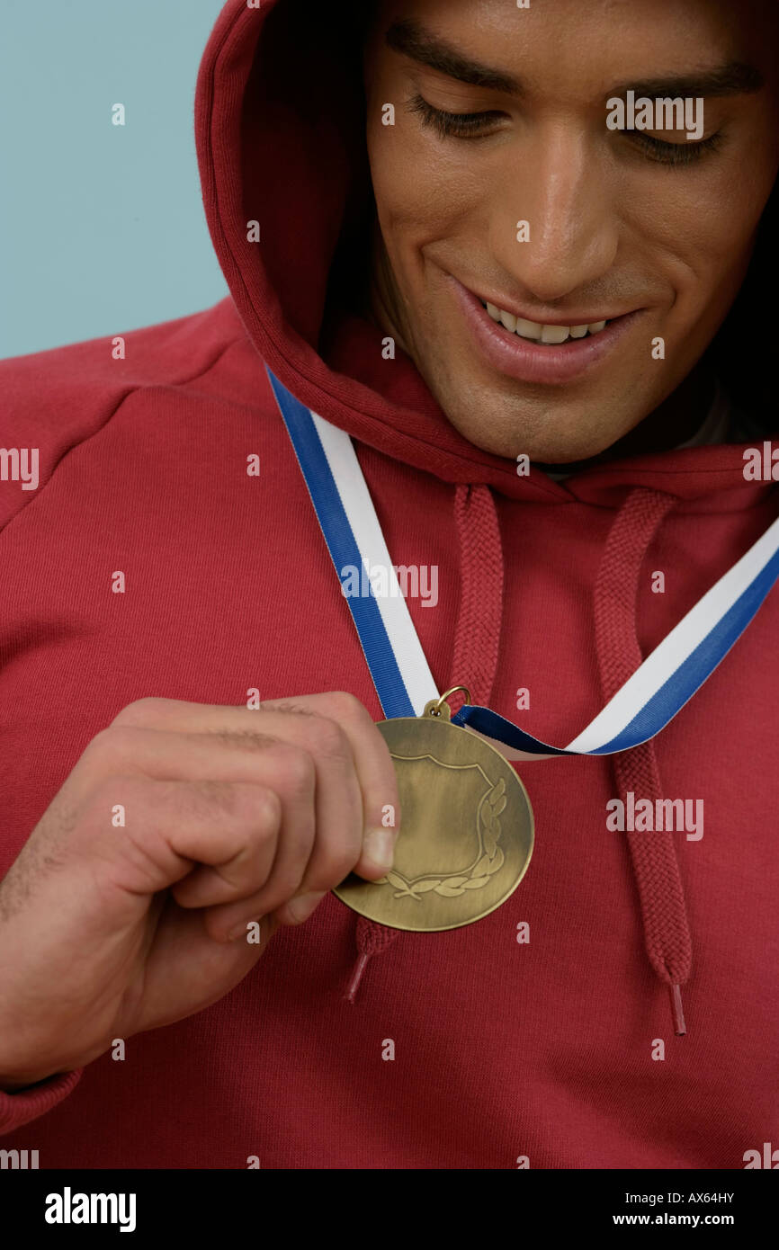 Smiling athlete holding a medal in his hand Stock Photo - Alamy