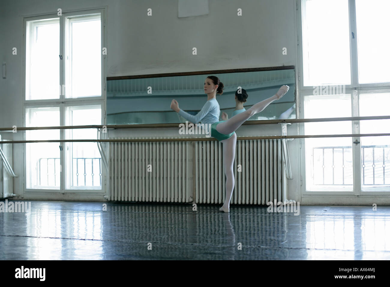 A female ballet dancer exercising a attitude at ballet bare Stock Photo ...
