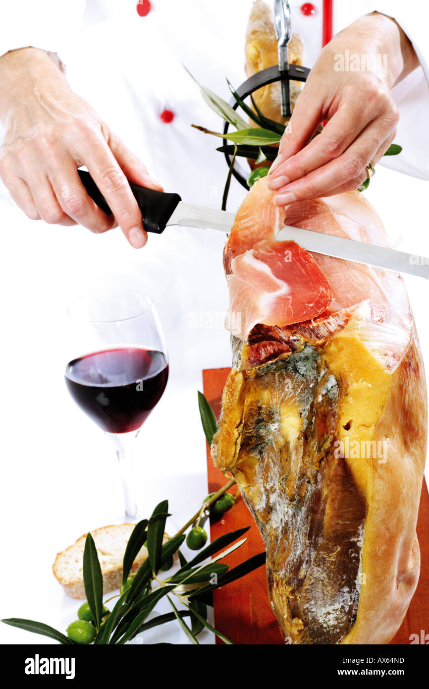 Chef cutting Serrano ham, close-up, mid section Stock Photo - Alamy