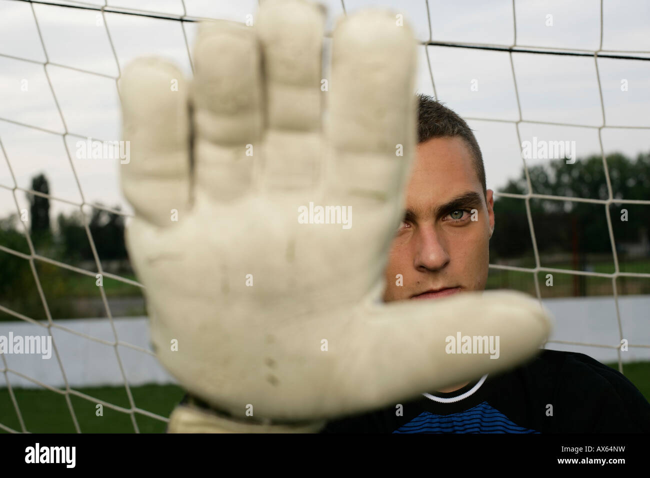 Goalkeeper holding hand with glove at camera Stock Photo - Alamy