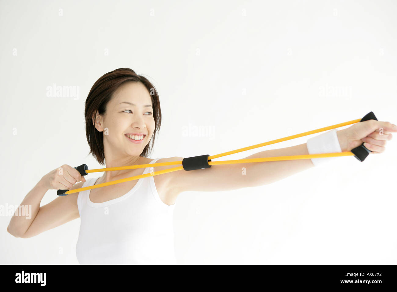 A young woman smiles as she uses the stretching rope for an exercise ...