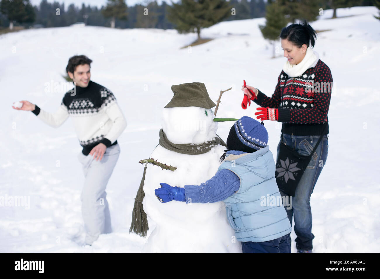 Family making a snowman Stock Photo - Alamy