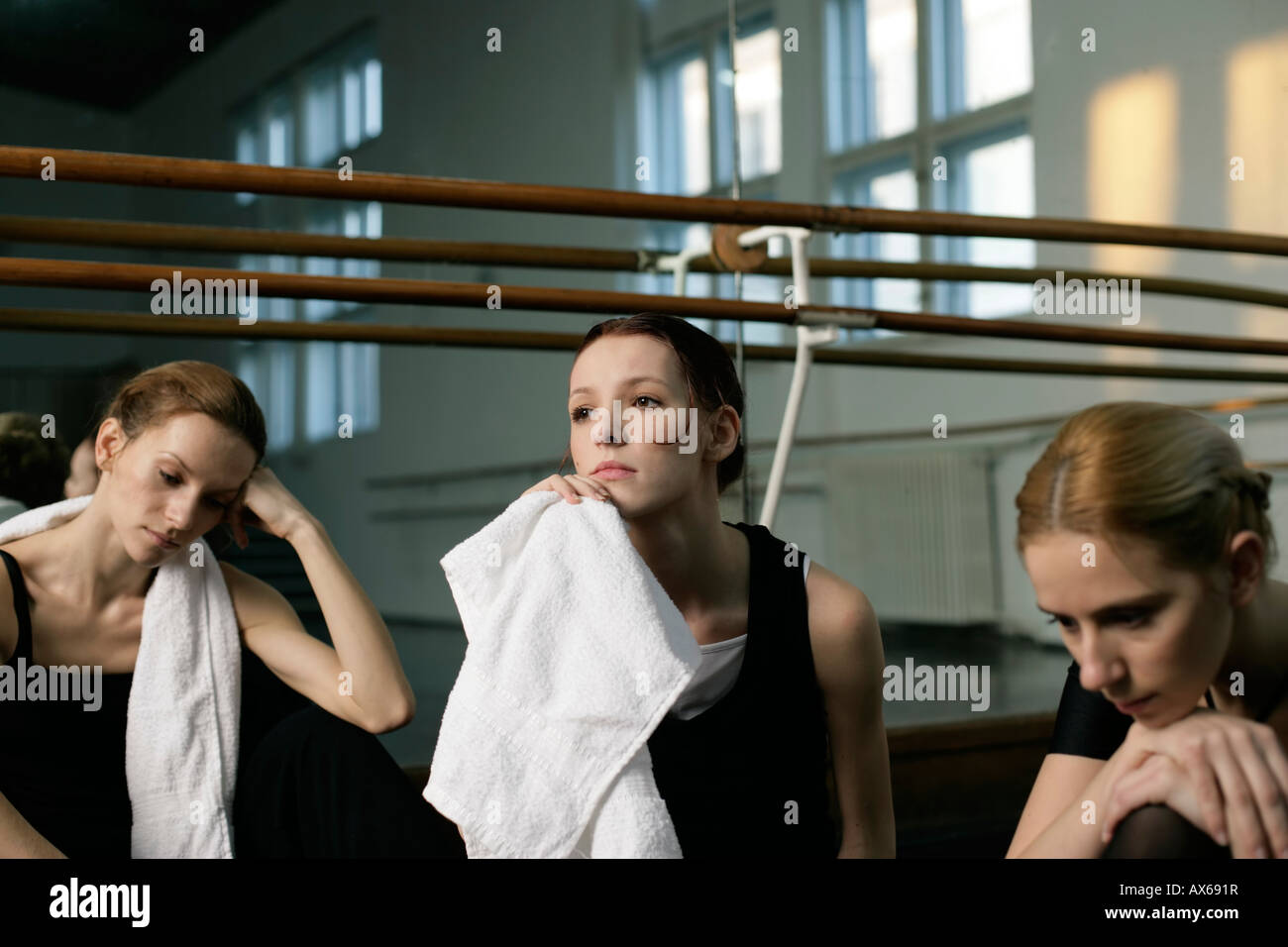 Exhausted female ballet dancers with towels sitting on the floor Stock ...